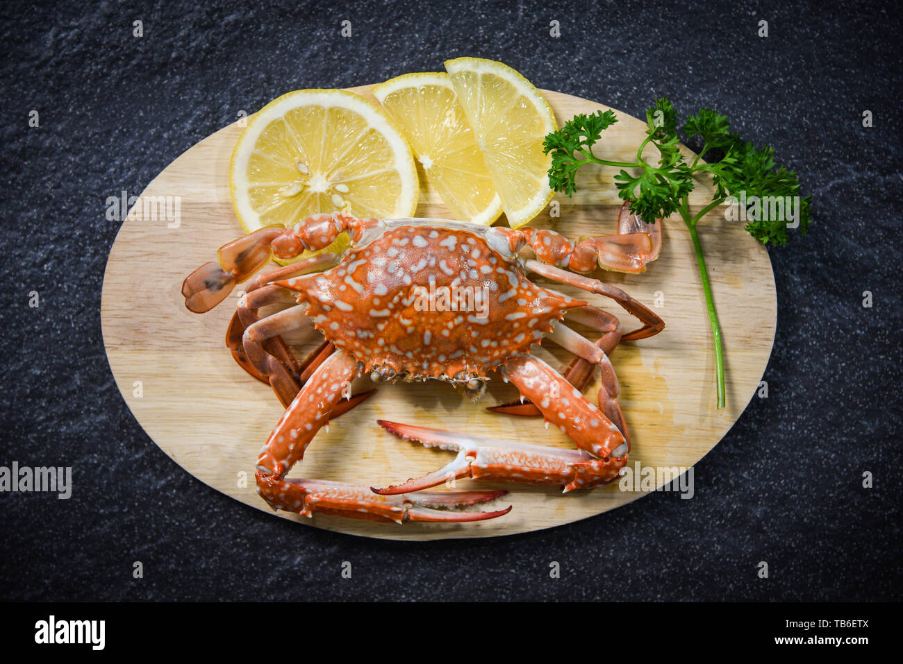 Crab cooked shellfish seafood on cutting board with herbs and spices on ...