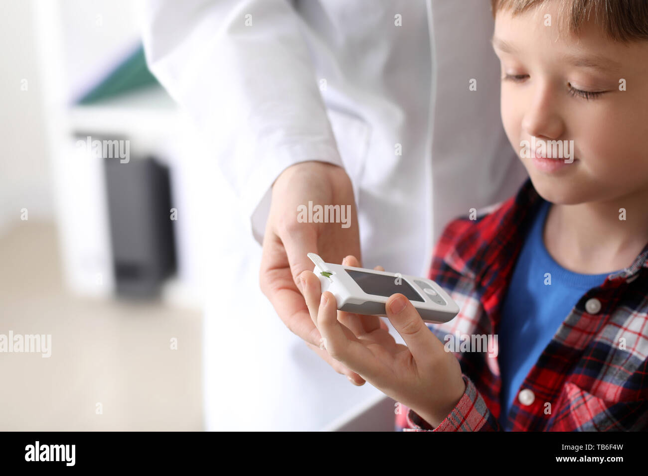 Diabetic child with digital glucometer and doctor in clinic Stock Photo ...