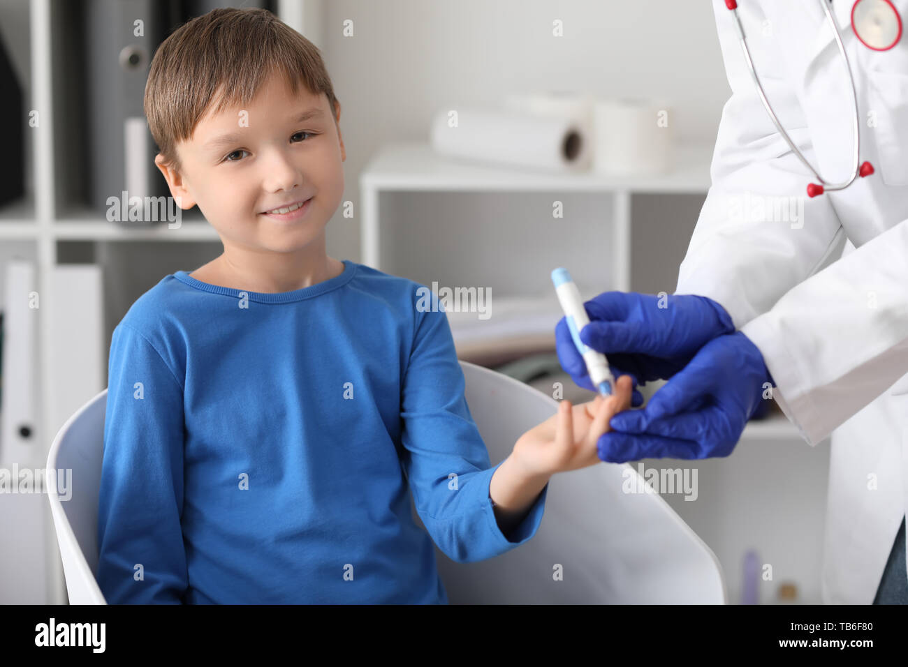 Doctor taking blood sample of diabetic child in clinic Stock Photo - Alamy