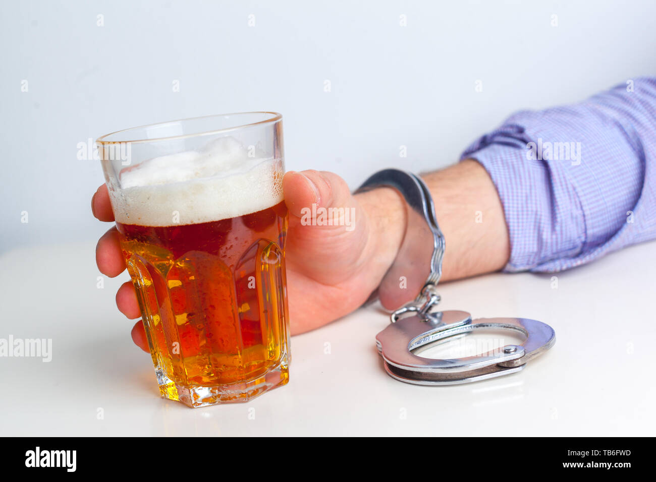 Glass of beer with handcuffs as symbol for alcohol abuse Stock Photo ...