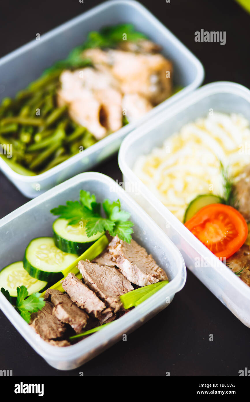 Food in containers on a black background, close up Stock Photo - Alamy