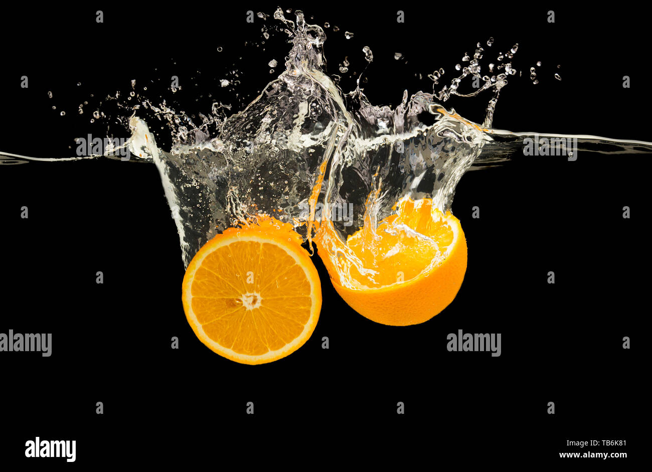 Fresh cut oranges falling in water with splash, black background Stock ...