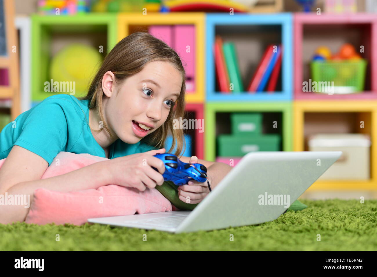 Portrait of cute little girl playing computer game Stock Photo - Alamy
