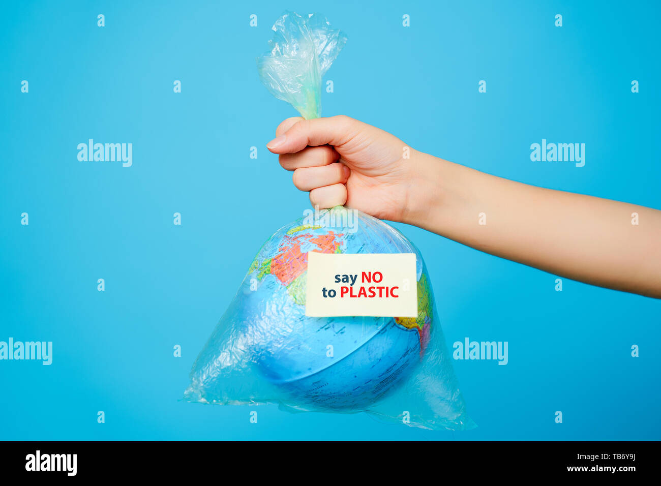 Woman holds in hands plastic bag and planet earth with text sticker-SAY ...