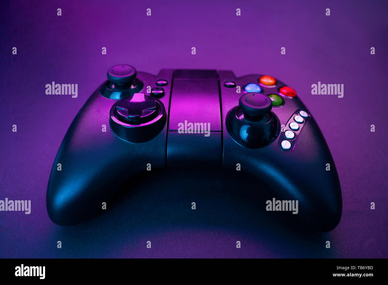 Gamepad on violet table background Stock Photo - Alamy