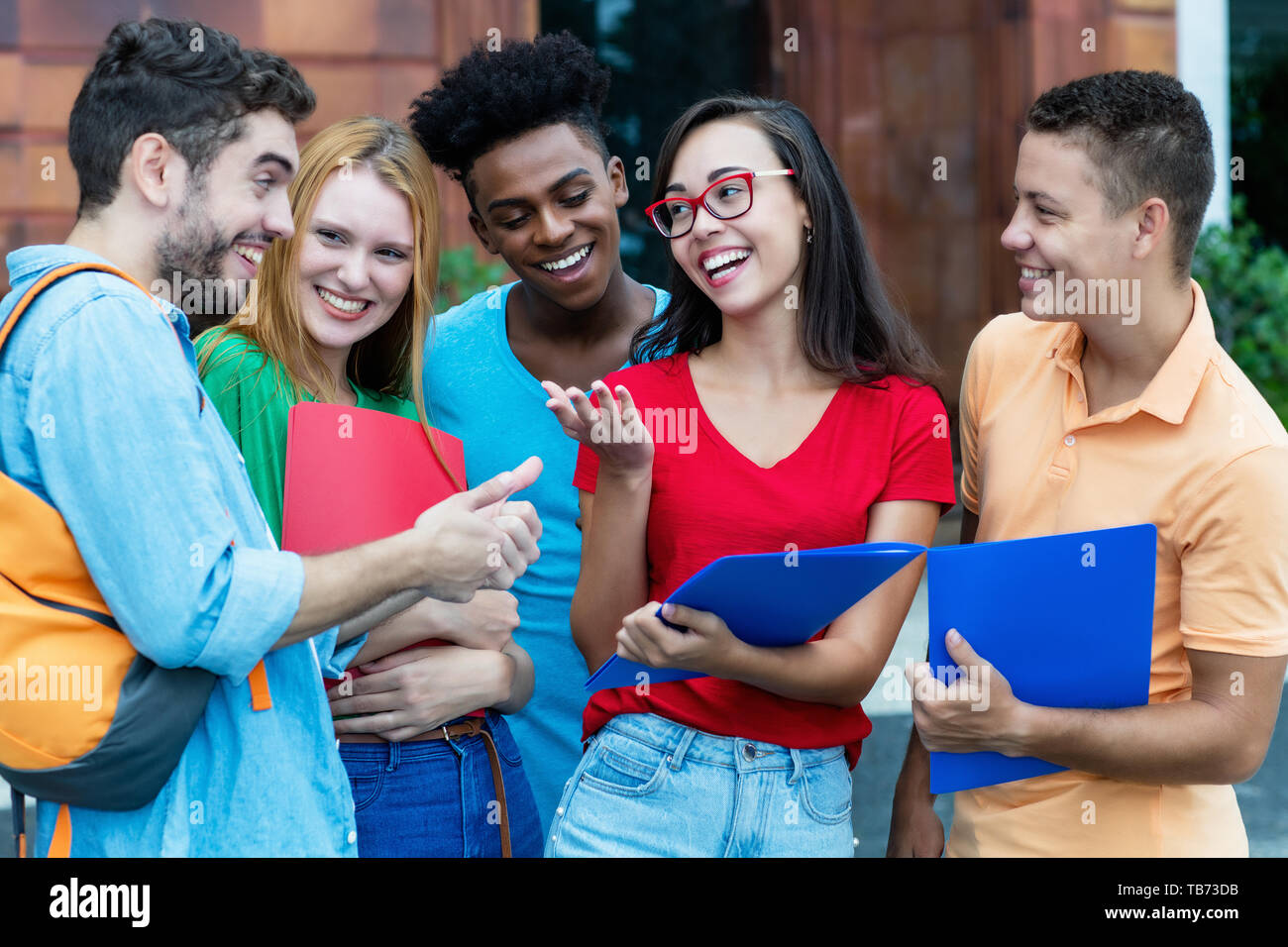 Group of american and latin and african students talking about homework ...