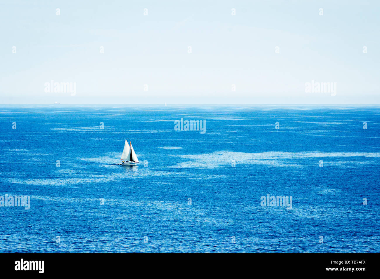 Photo of seaside landscape with a white sailboat. Sailing boat on the ...