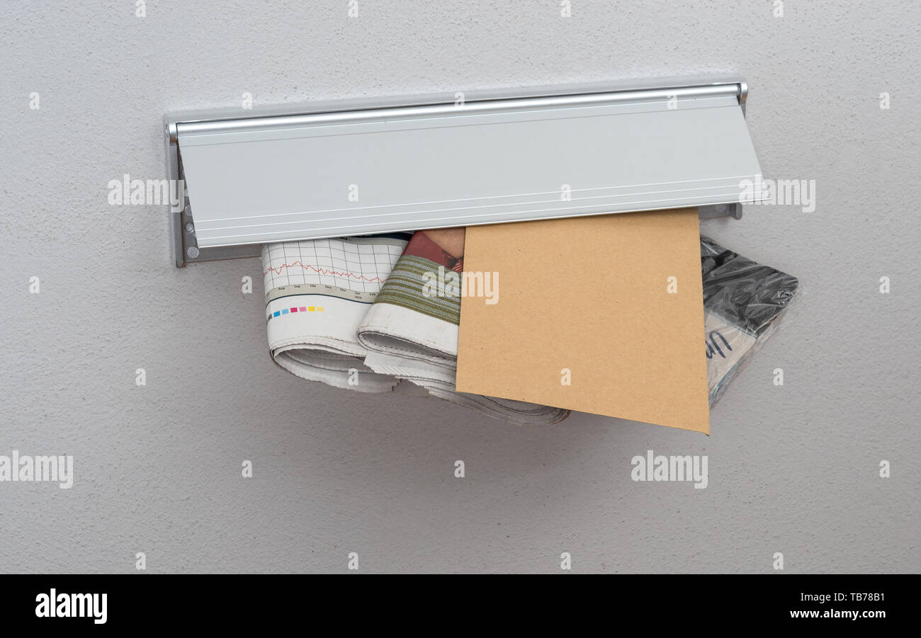 A letter and newspapers in a mail slot Stock Photo - Alamy