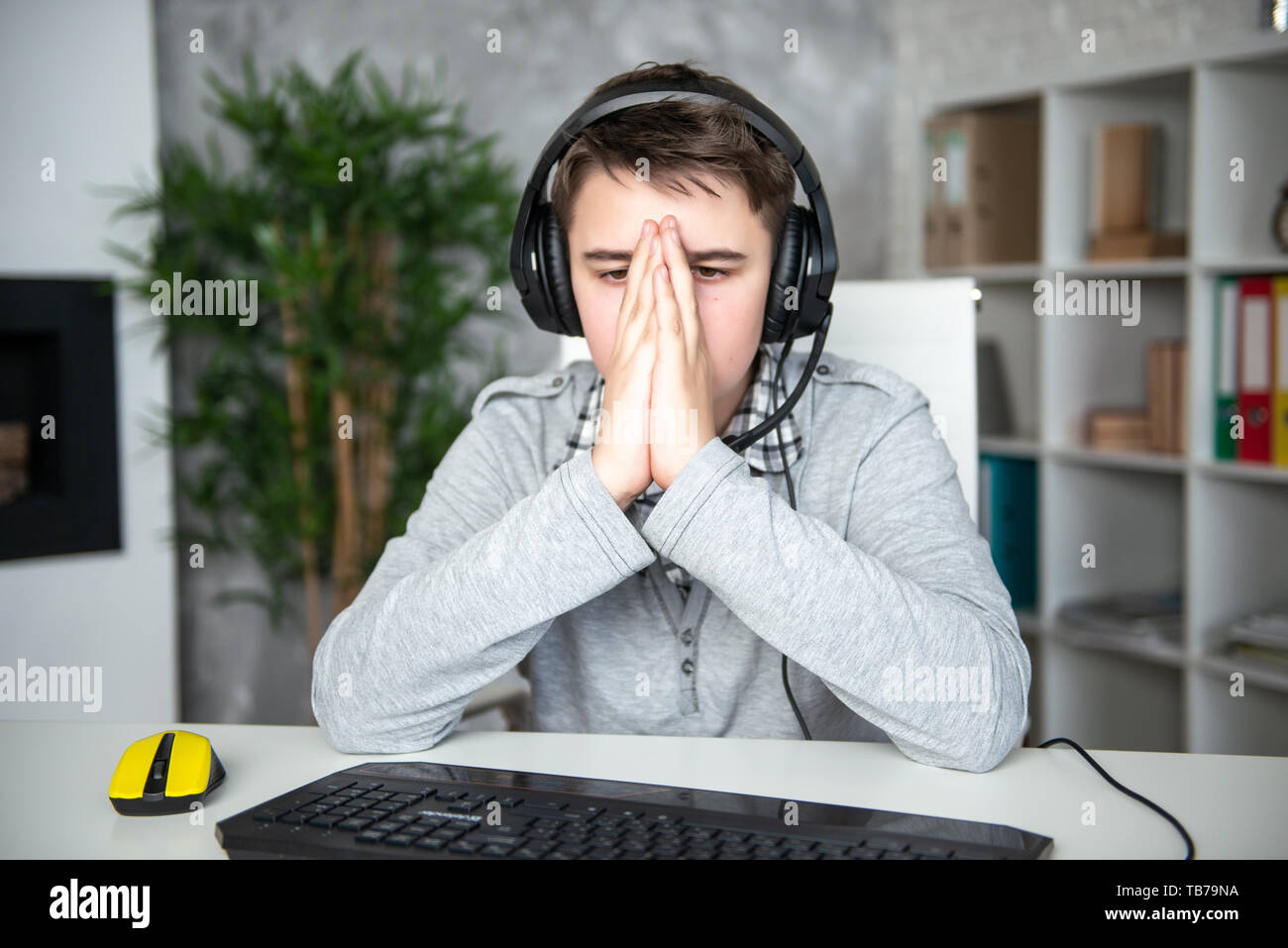 Oops, failure, loss. Teenager boy lost in a computer game. A schoolboy ...