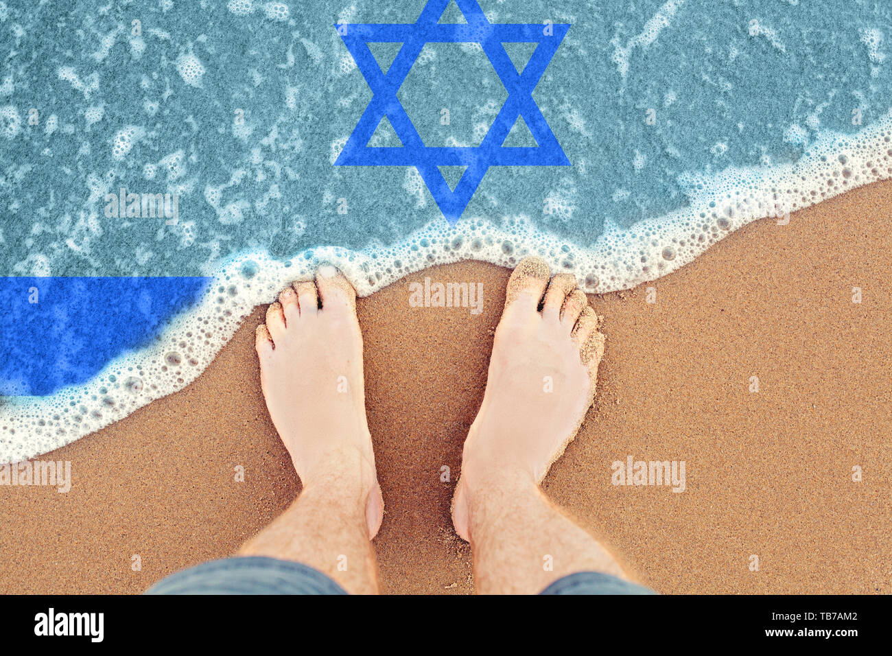 Feet on the sunny sandy beach with flag Israel. Top View on sea surf ...