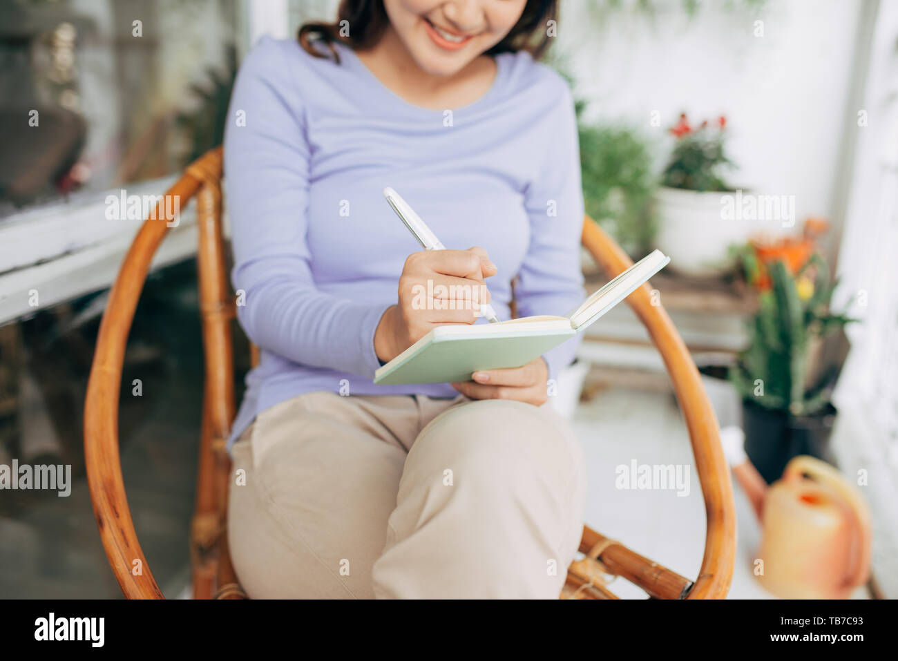 Happy Beautiful Woman writing something into her diary. Enjoying ...