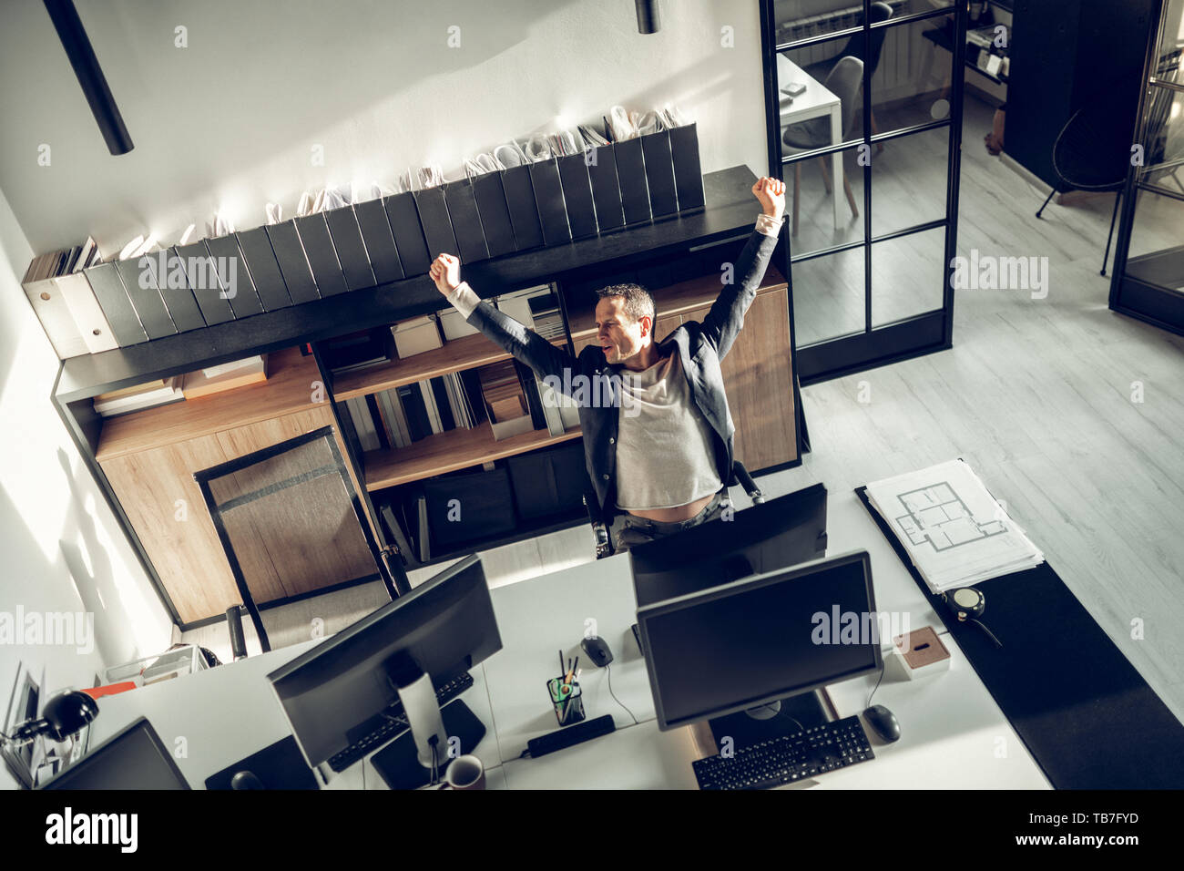 Hard-working businessman stretching his back after working too long ...