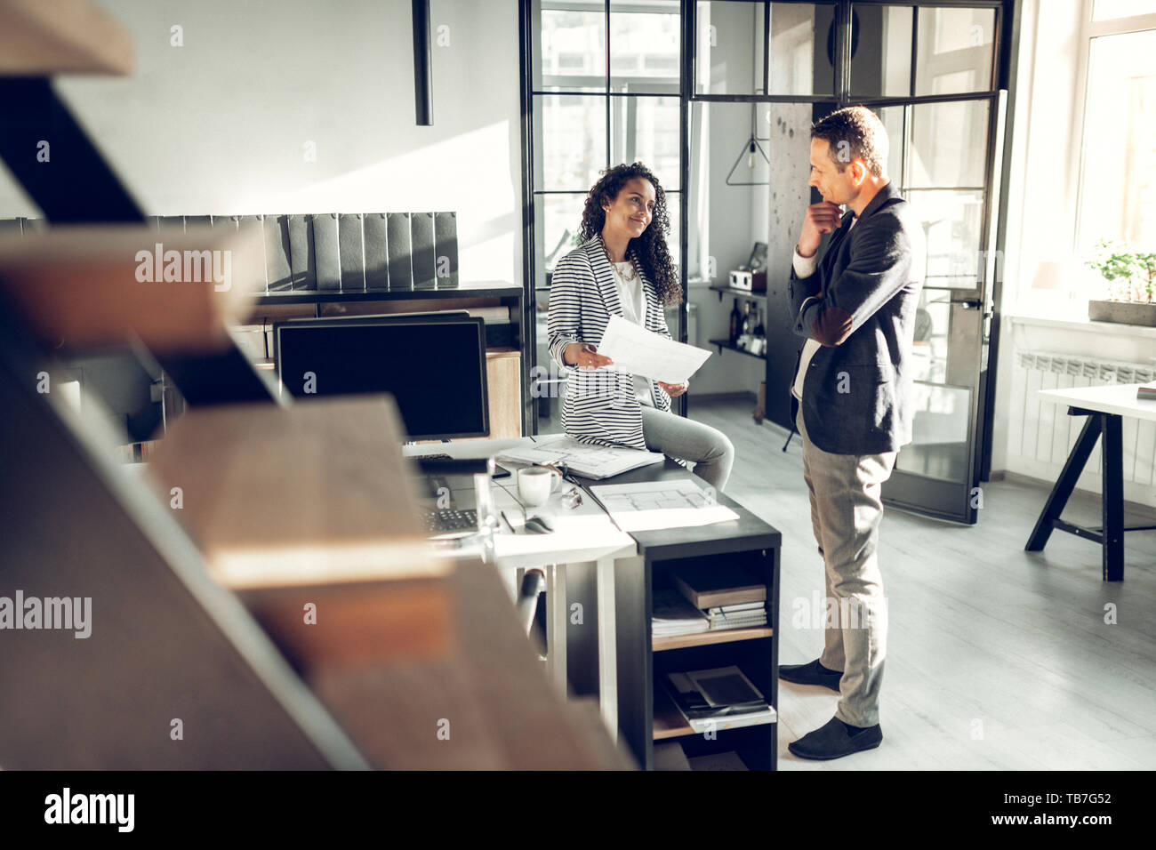 Woman smiling while working with professional businessman Stock Photo ...