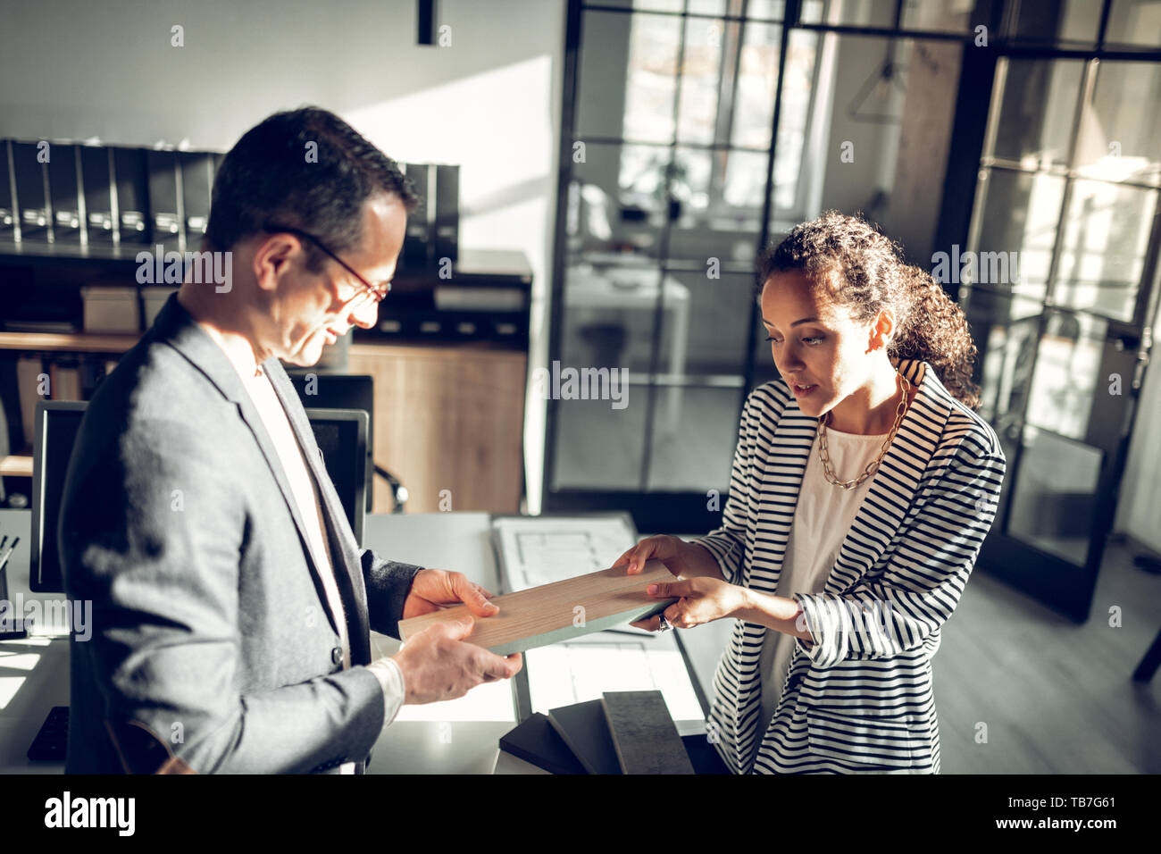 Curly secretary with ponytail giving report to her busy boss Stock ...