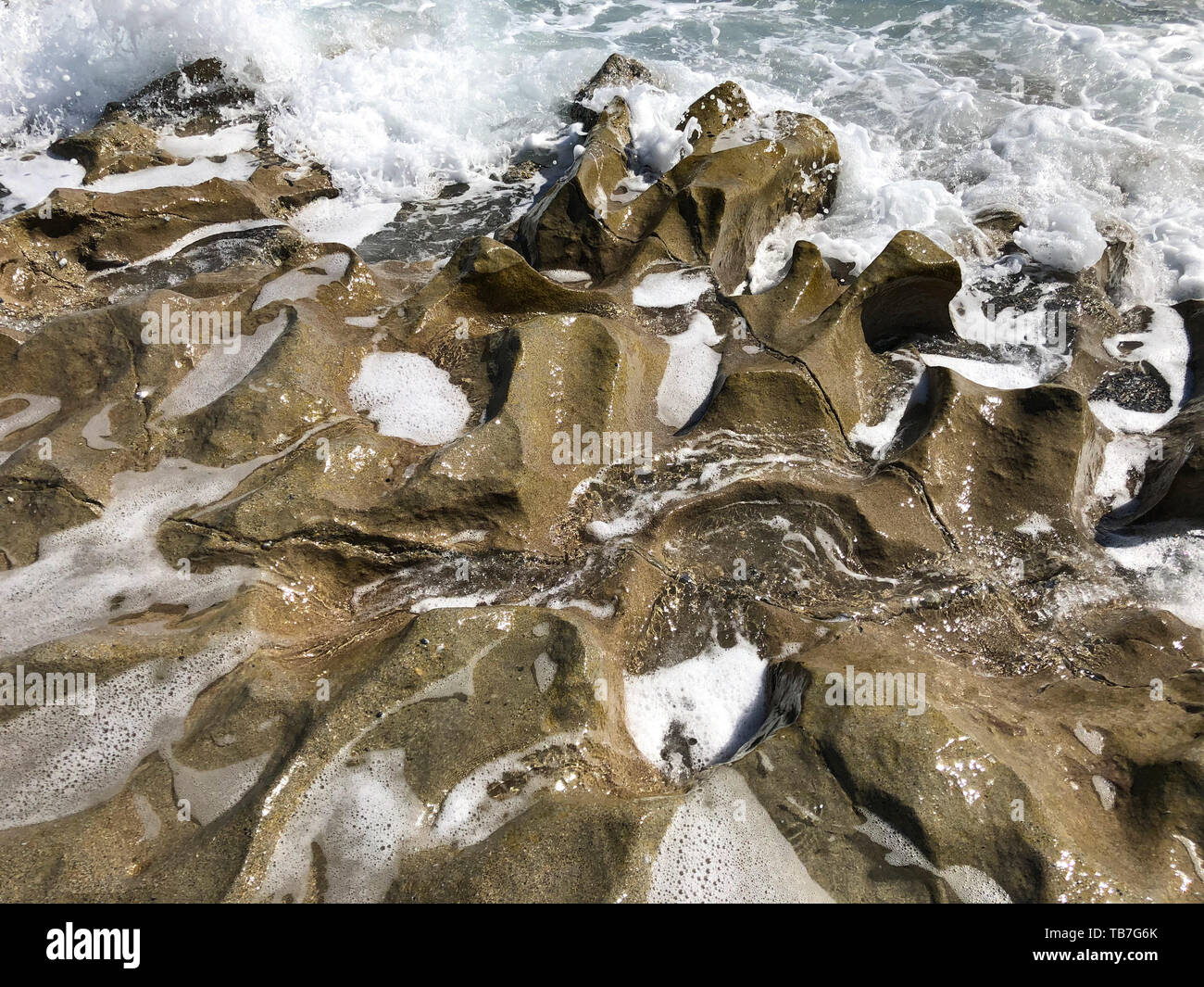 Stones by the sea of fancy shape and color. Foamy surf of the sea Stock ...