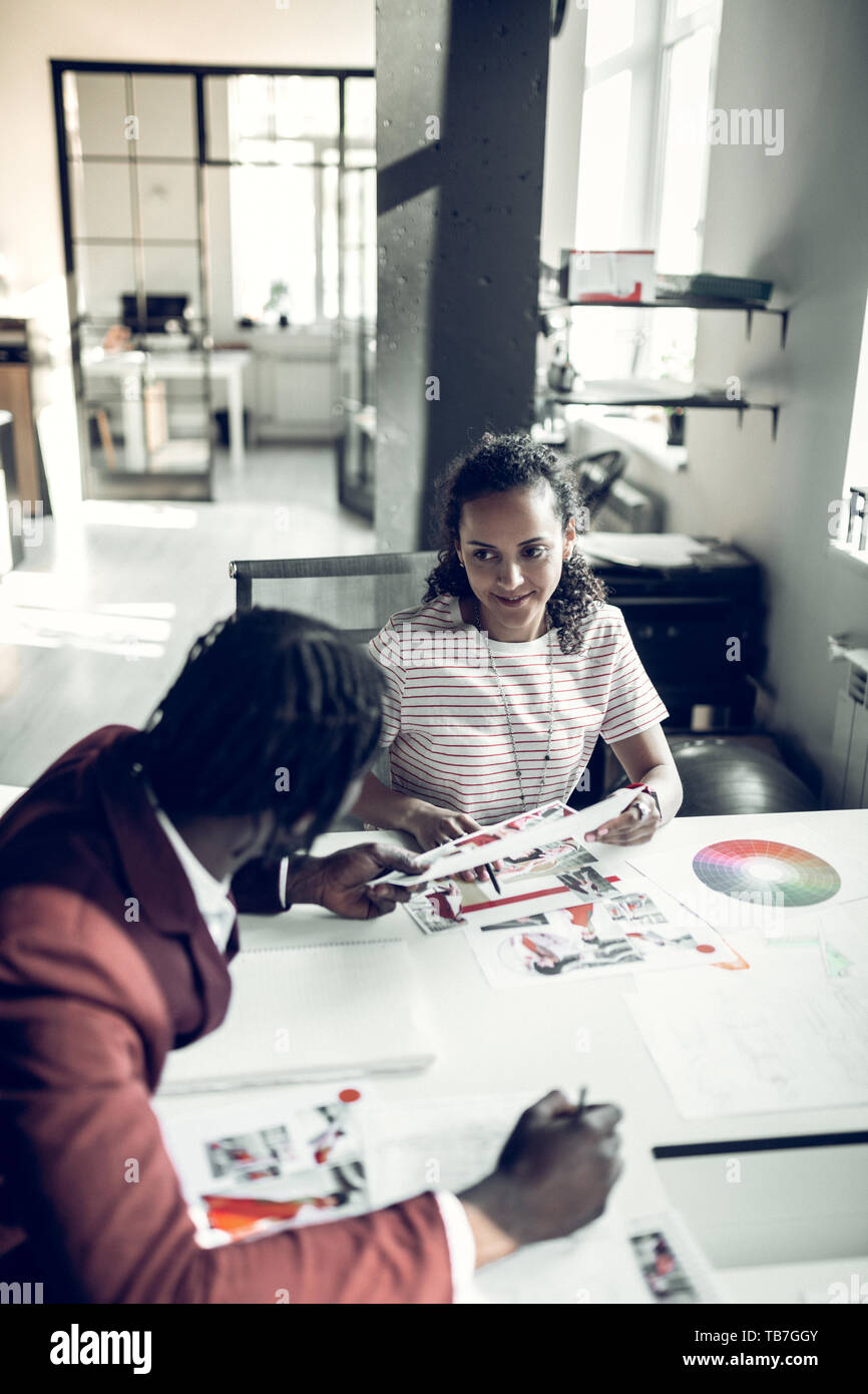 Dark-skinned interior designer talking to his helpful secretary Stock ...