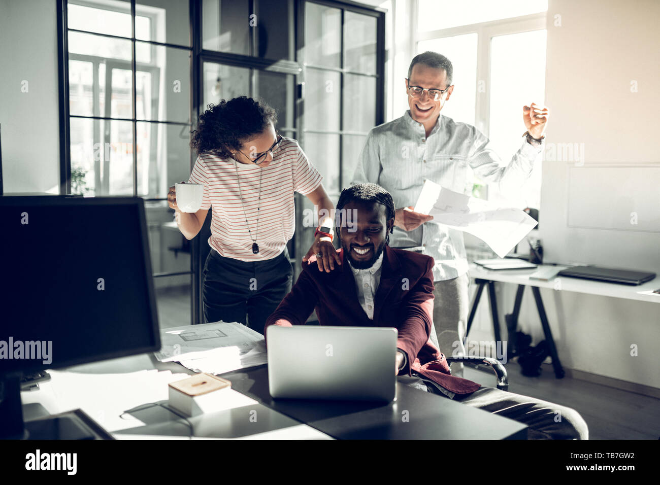 Staff of the company supporting their dark-skinned boss Stock Photo - Alamy