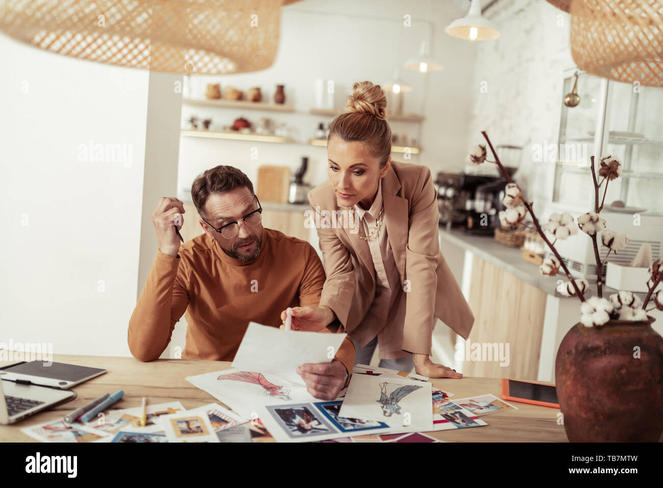 Asking for help. Beautiful concentrated assistant helping fashion ...