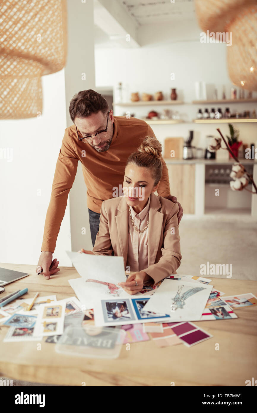 Creating together. Concentrated handsome fashion designer and his ...