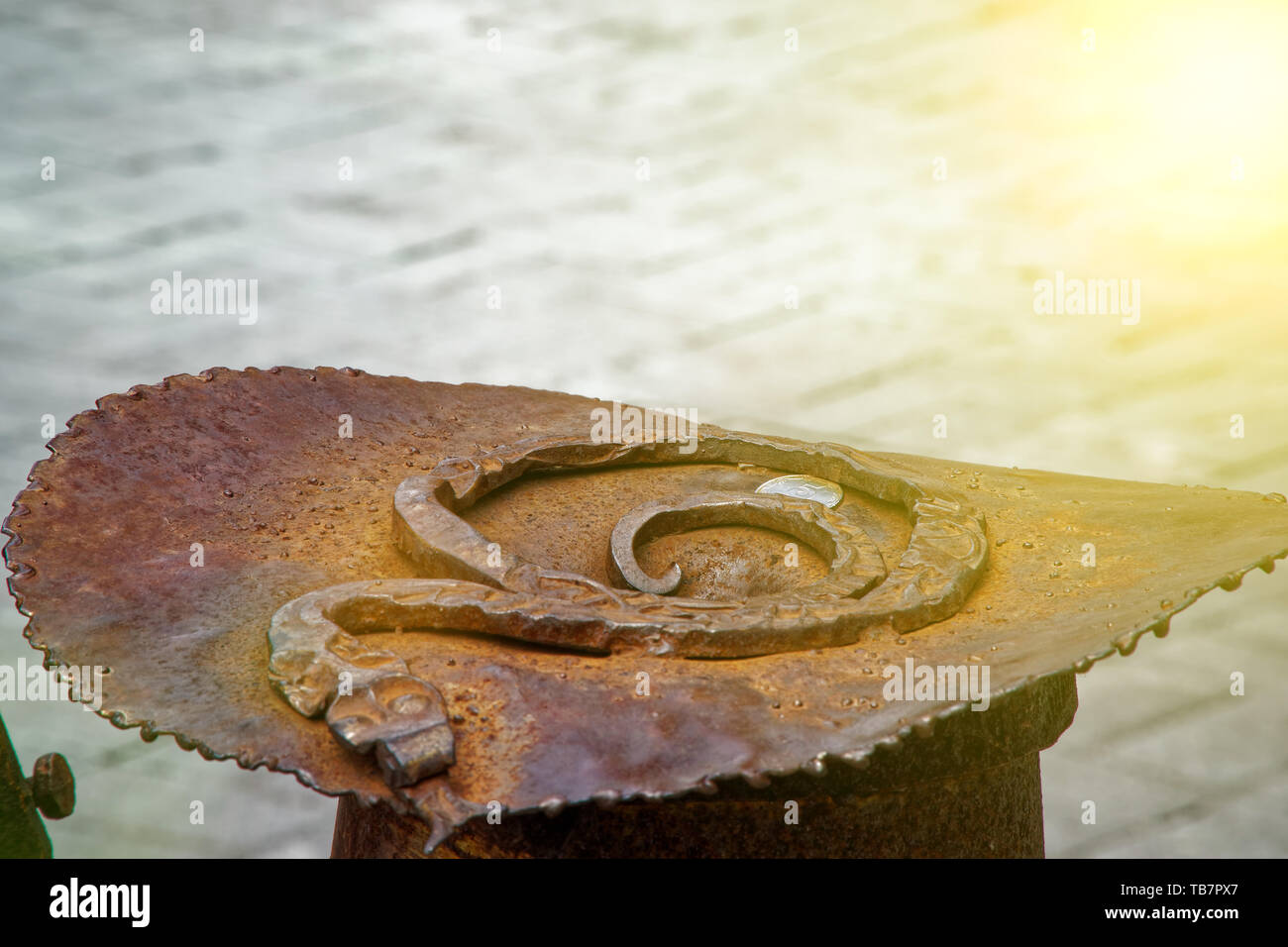 Weathered rusty metal element on the street, shaped detail closeup ...