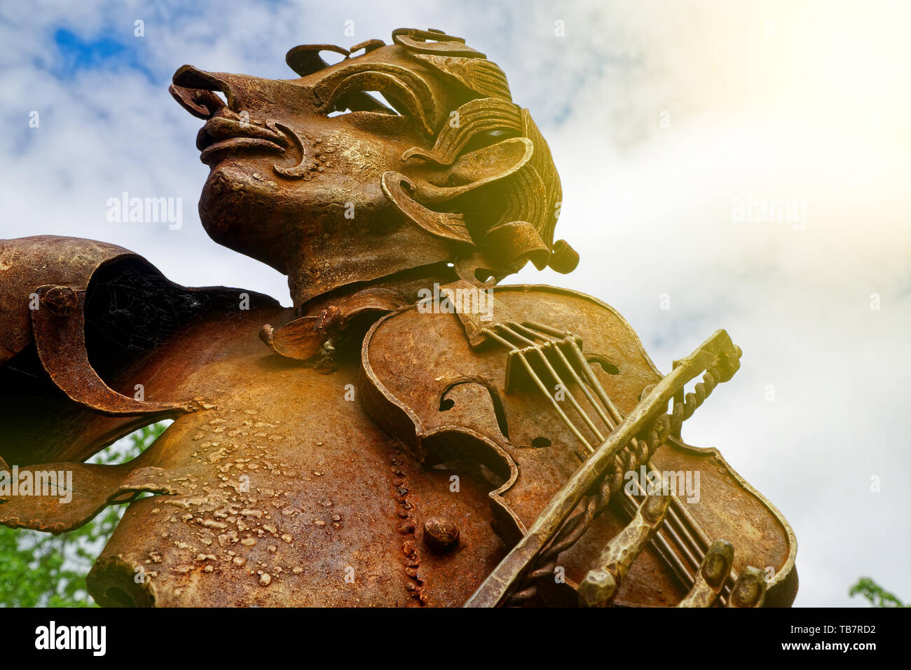 Face of an old rusty statue with iron violin Stock Photo - Alamy