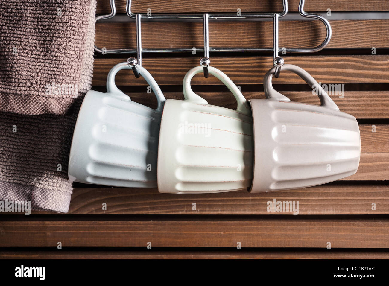 Different tea cups hanging on wooden wall Stock Photo - Alamy