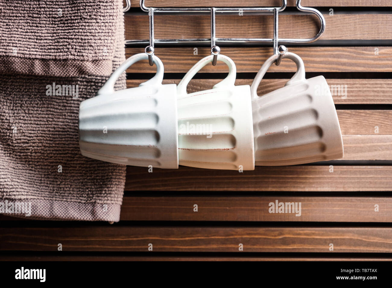 Different tea cups hanging on wooden wall Stock Photo - Alamy