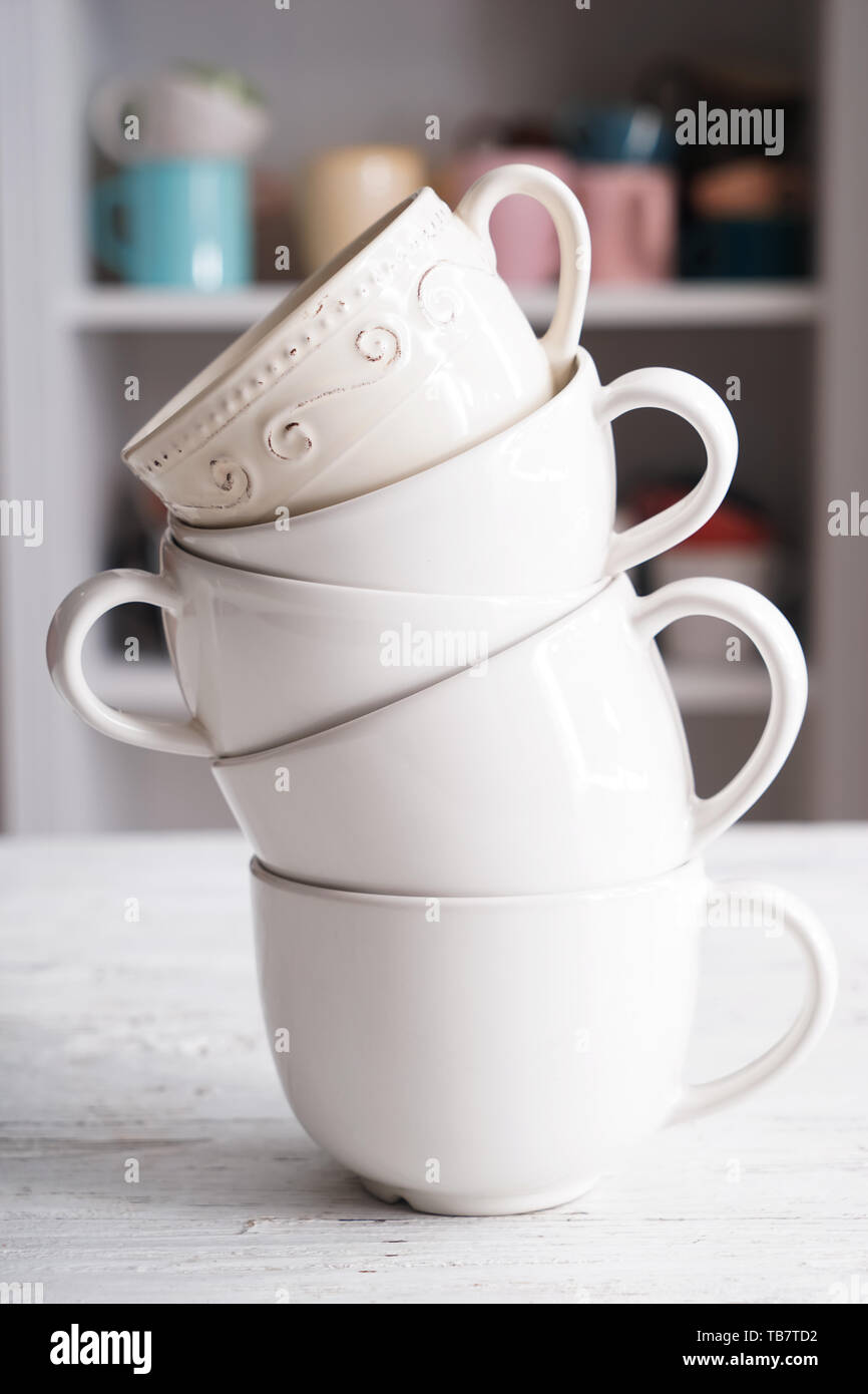 Stack of ceramic cups on white table Stock Photo - Alamy