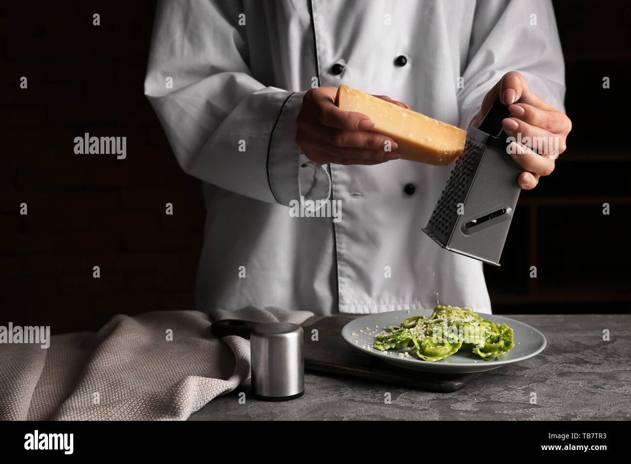 Chef grating cheese over plate with tasty ravioli Stock Photo - Alamy