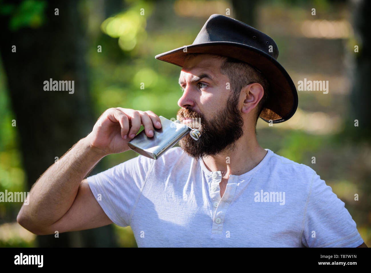 Hipster with beard drink alcohol nature background defocused. Hiking ...