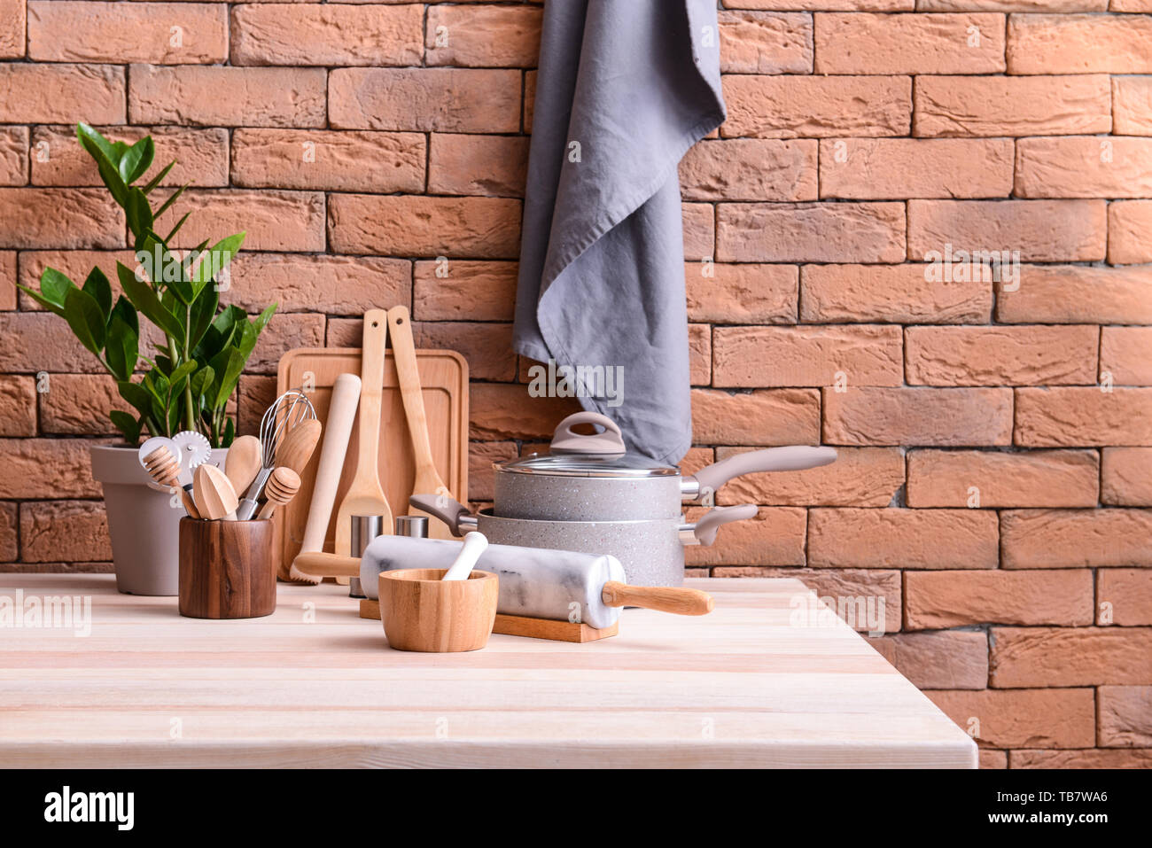 Set of kitchen utensils on table near brick wall Stock Photo - Alamy