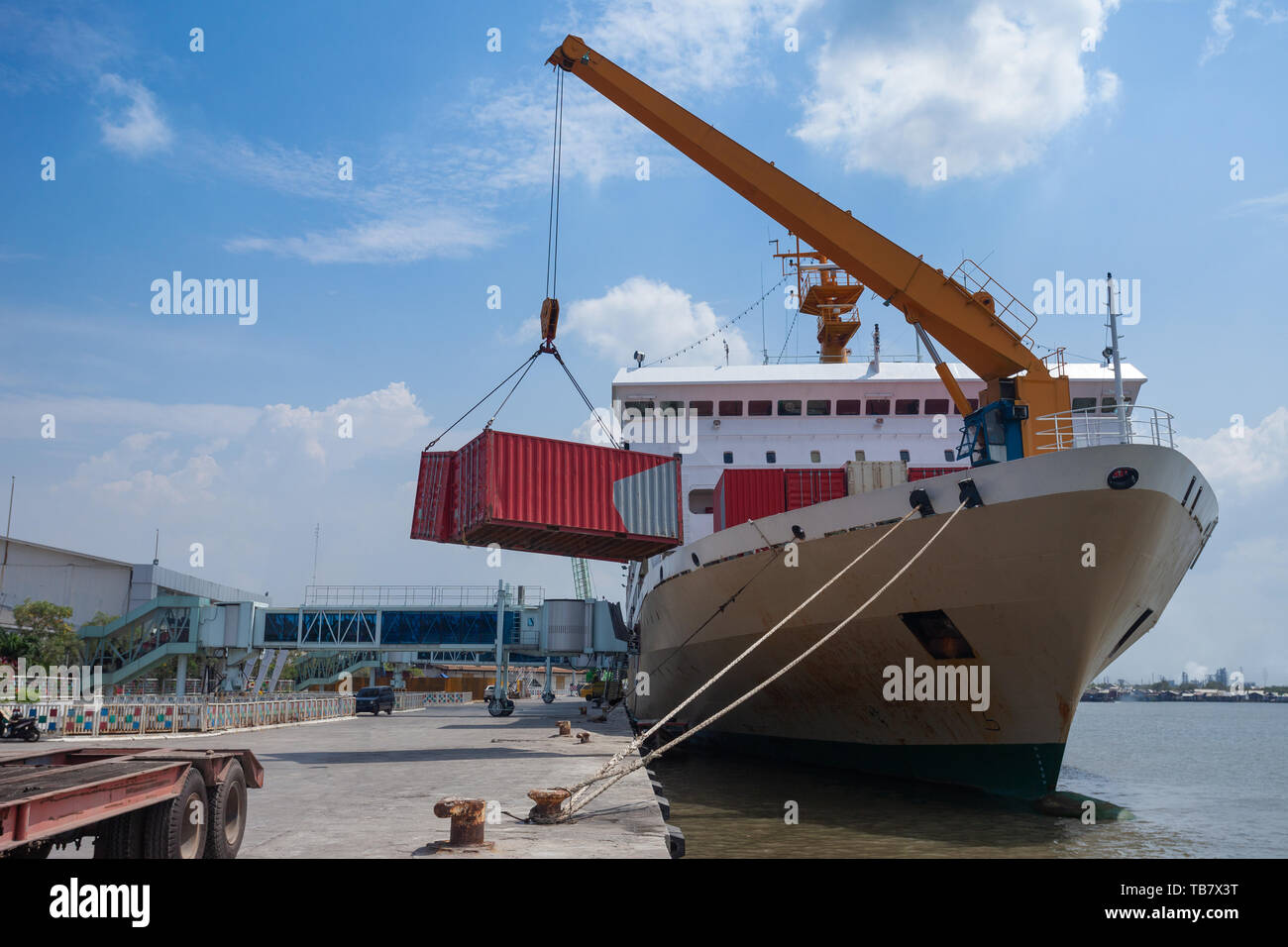 Dockworkers unload containers from a ship while docked in Indonesia ...