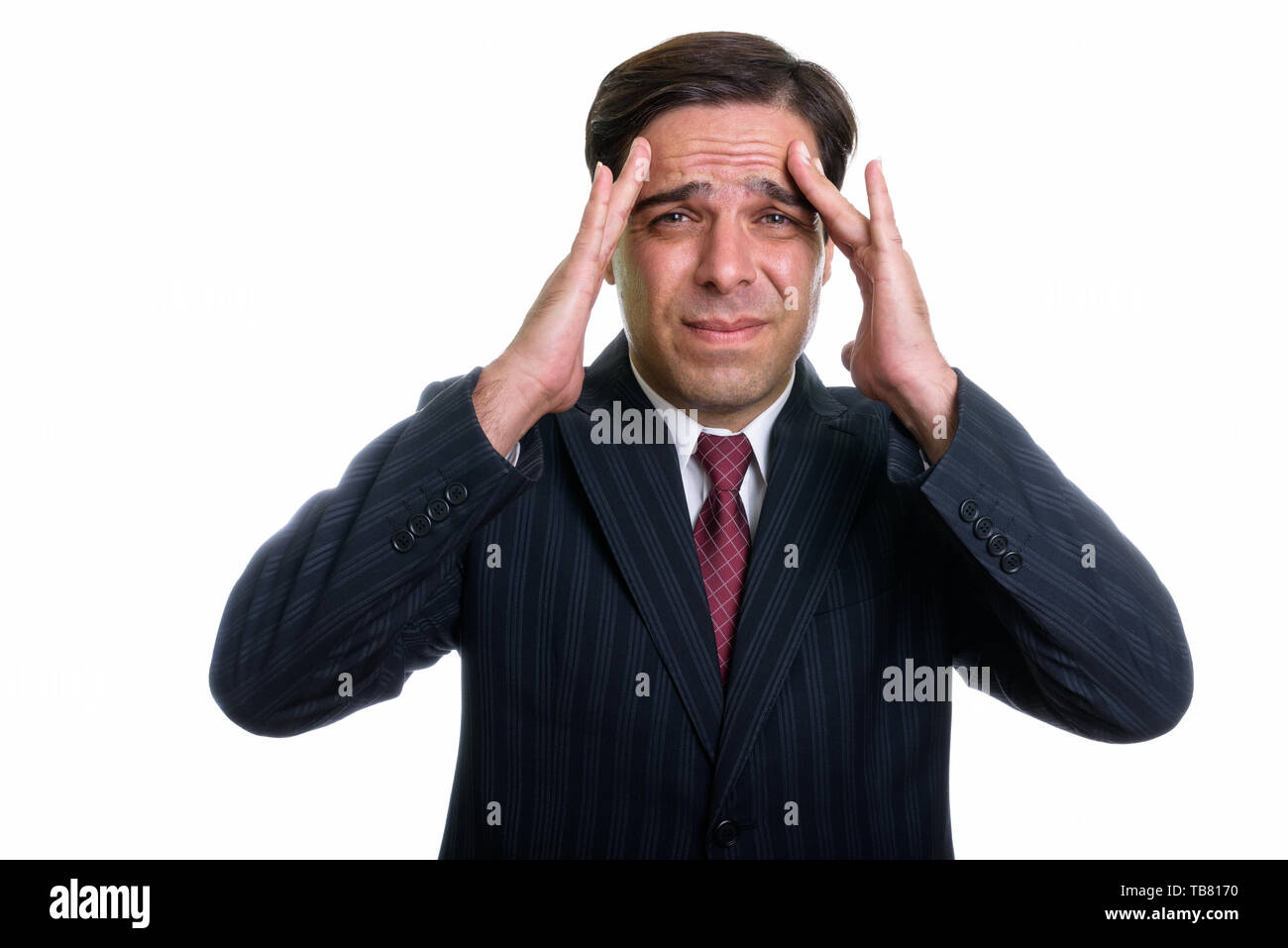 Studio shot of young stressed Persian businessman having headache with ...