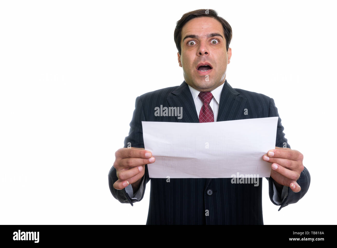 Studio shot of young Persian businessman holding paper while looking ...