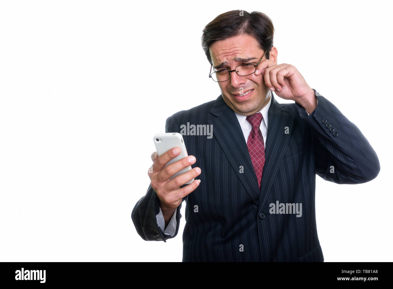 Studio shot of young Persian businessman using mobile phone while ...