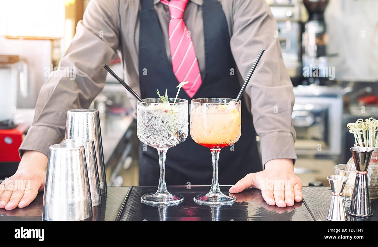 Young bartender making cocktails at bar counter - Barman serving drinks ...