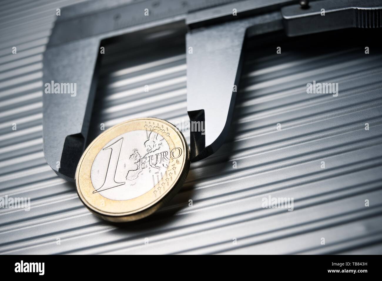 metal gauge measuring a one euro coin on a metal surface Stock Photo ...