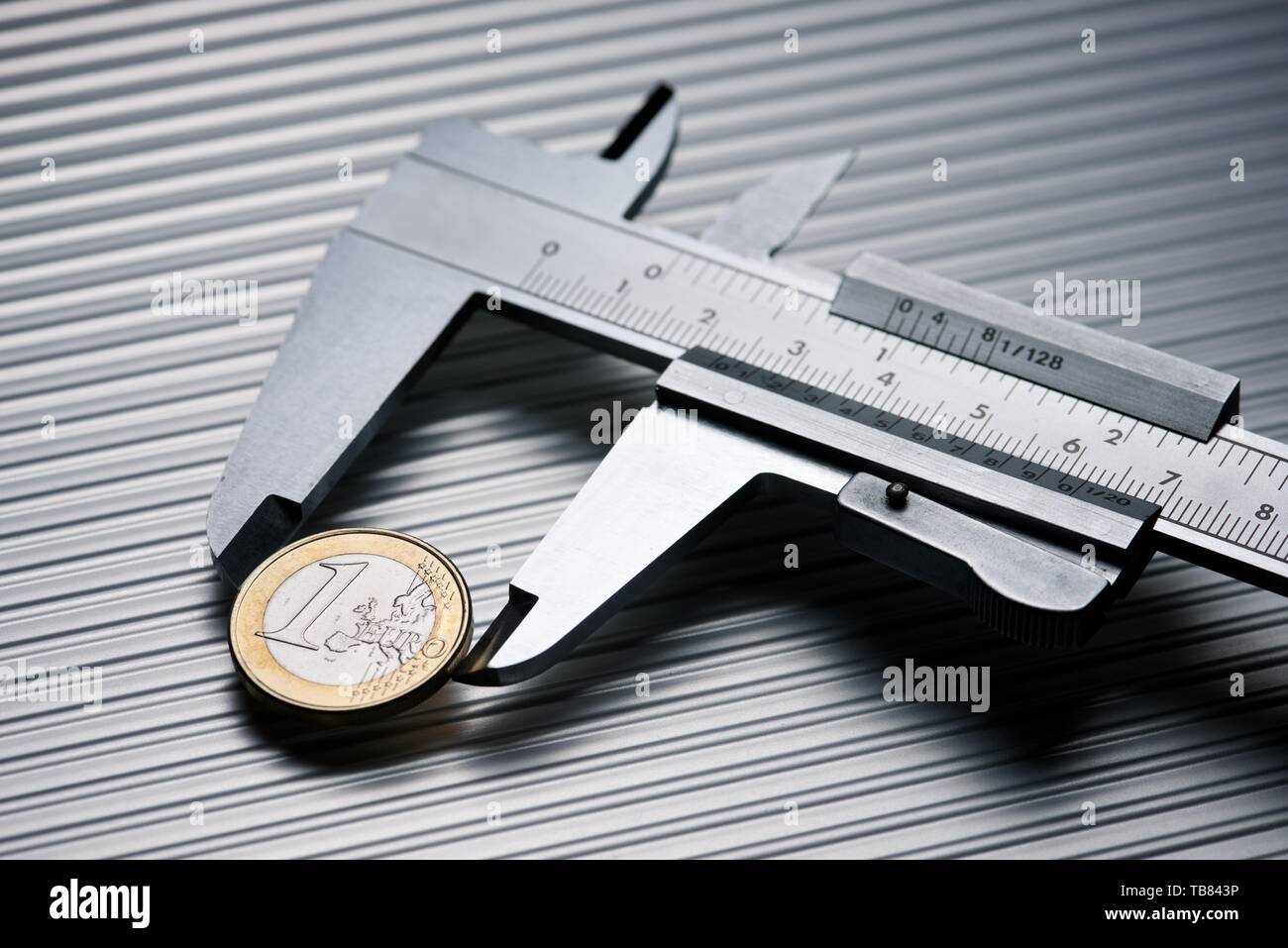 metal gauge measuring a one euro coin on a metal surface Stock Photo ...