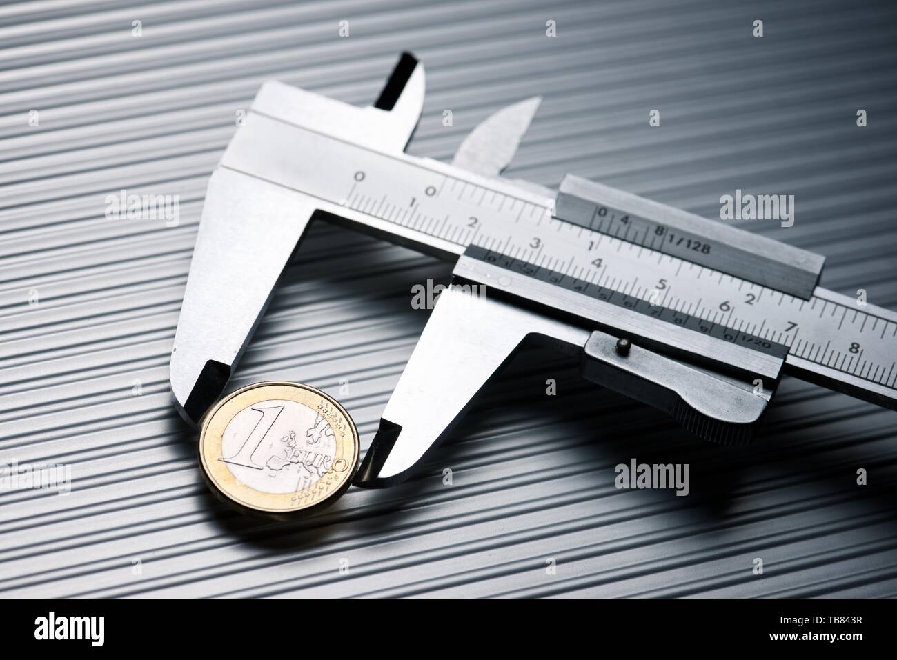 metal gauge measuring a one euro coin on a metal surface Stock Photo ...
