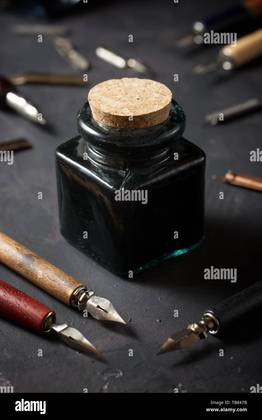 Nib pens for calligraphy and inkwell on a table Stock Photo - Alamy