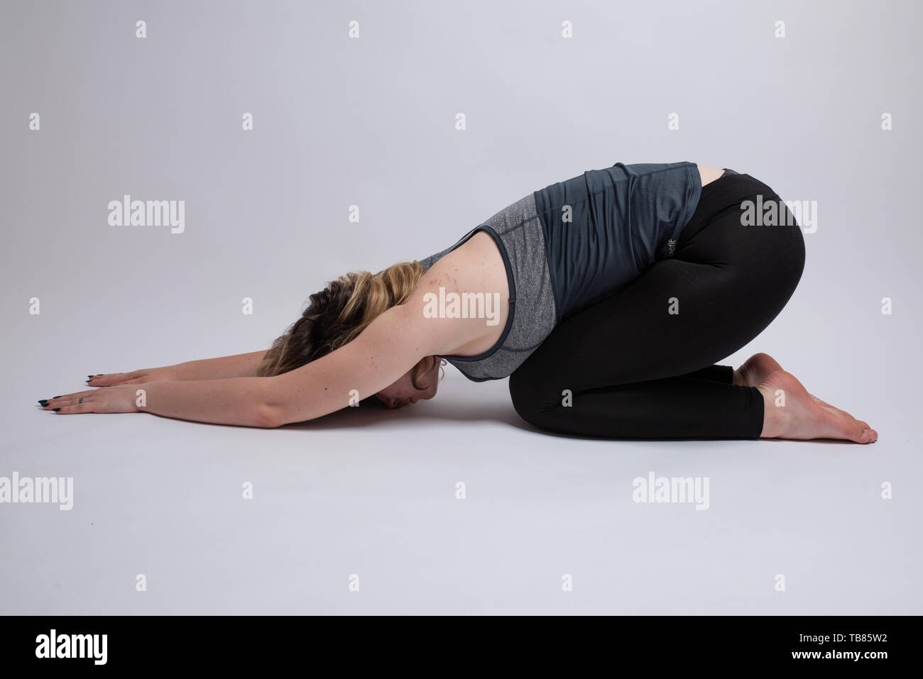 Ardha Kurmasana Half Tortoise yoga pose done by a woman. Flexibility ...