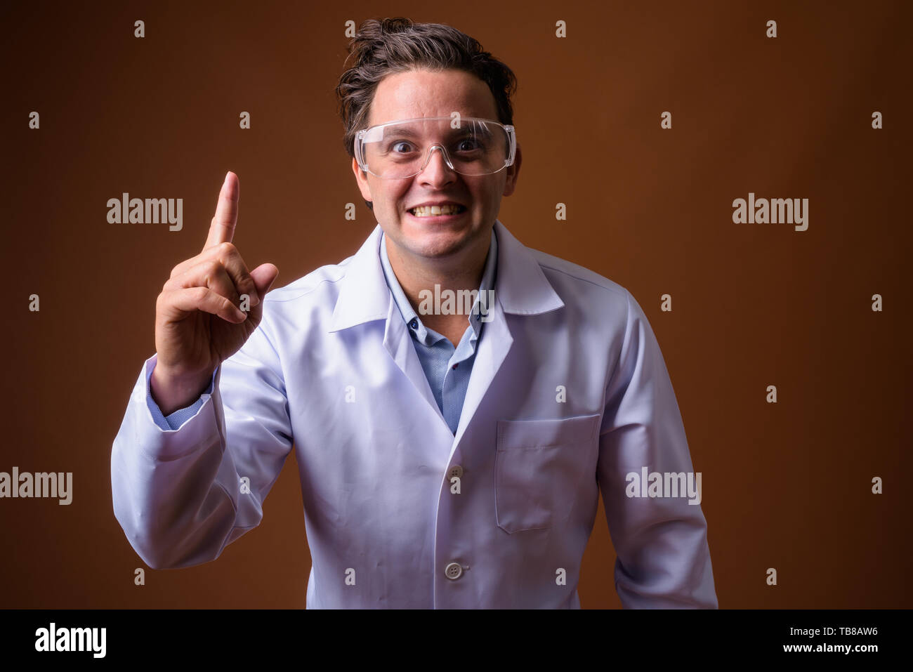 Studio shot of Italian man doctor wearing protective glasses against ...
