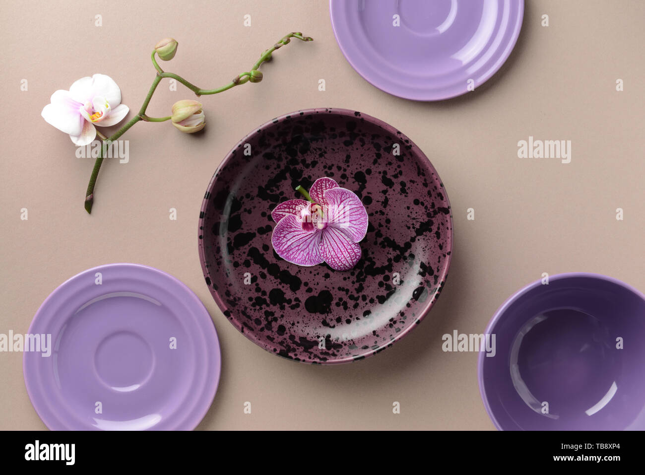Composition with plates and orchid flowers on table Stock Photo - Alamy