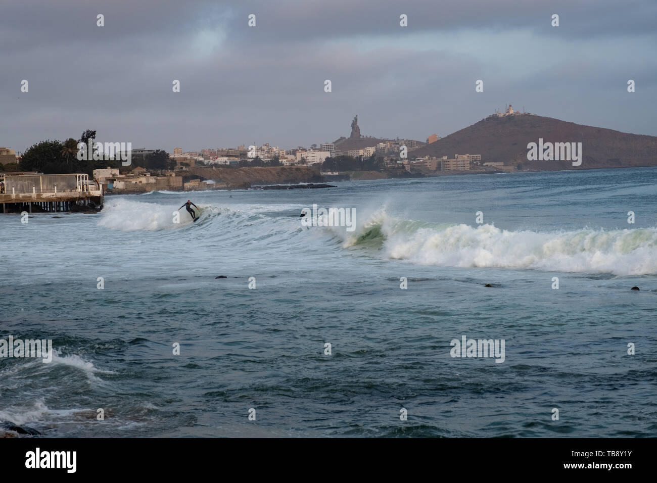 People surf on a beach in Dakar, Senegal, with the African Renaissance ...