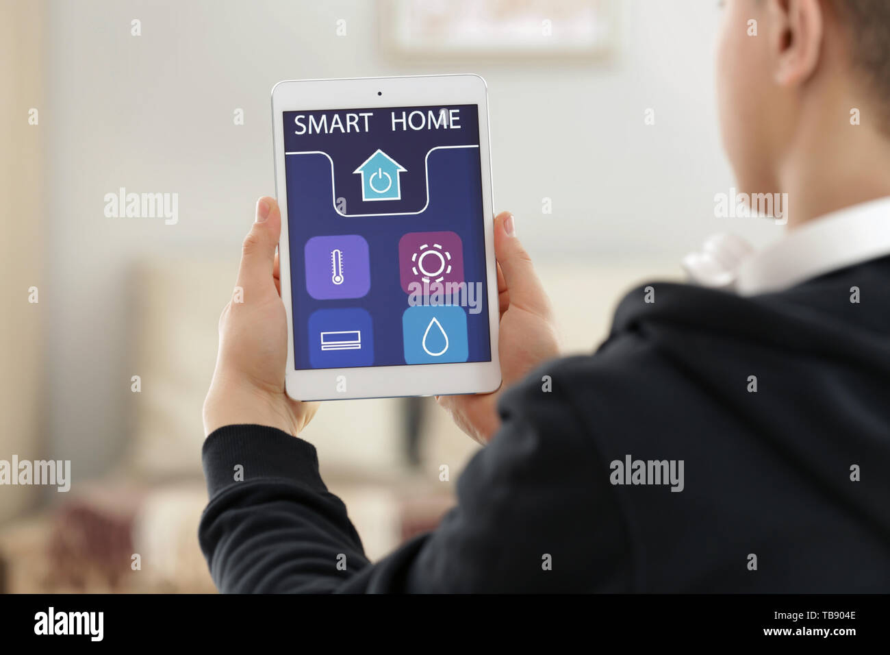 Teenage boy using application of smart home automation Stock Photo - Alamy