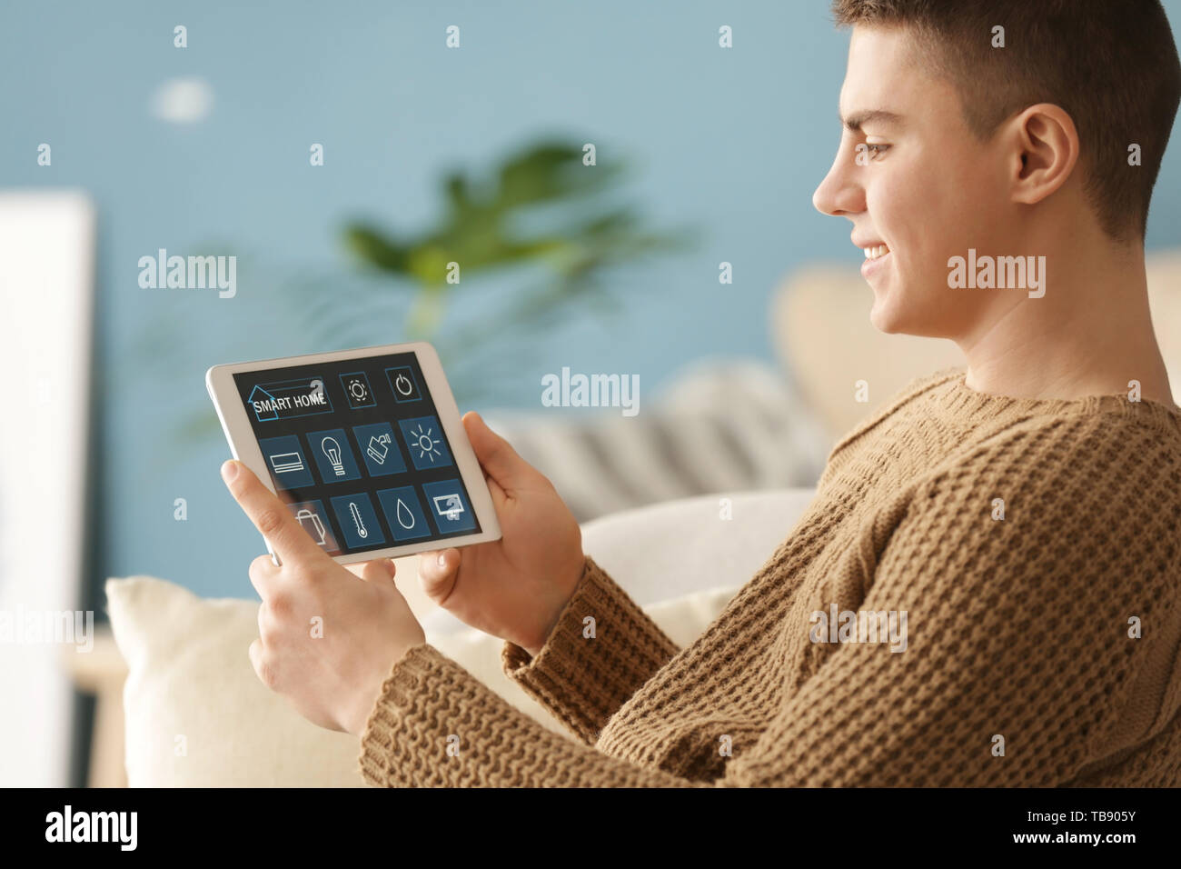 Teenage boy using application of smart home automation Stock Photo - Alamy
