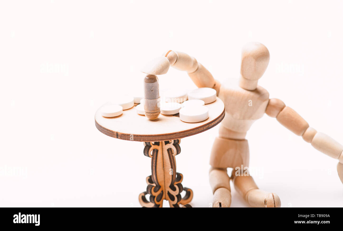 Health care and medical treatment. Pills on tiny wooden table ...