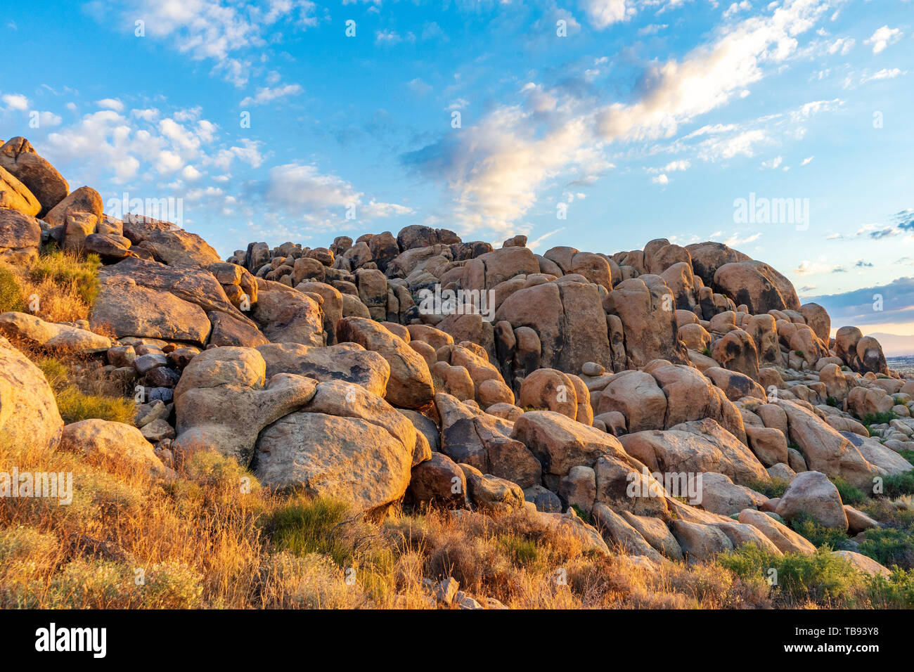 Large boulders on a hill during sunset lighting with blue sky and ...