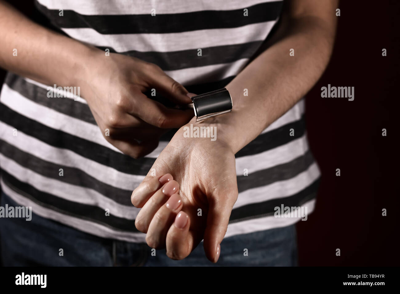 Woman cutting veins with razor blade on dark background, closeup ...