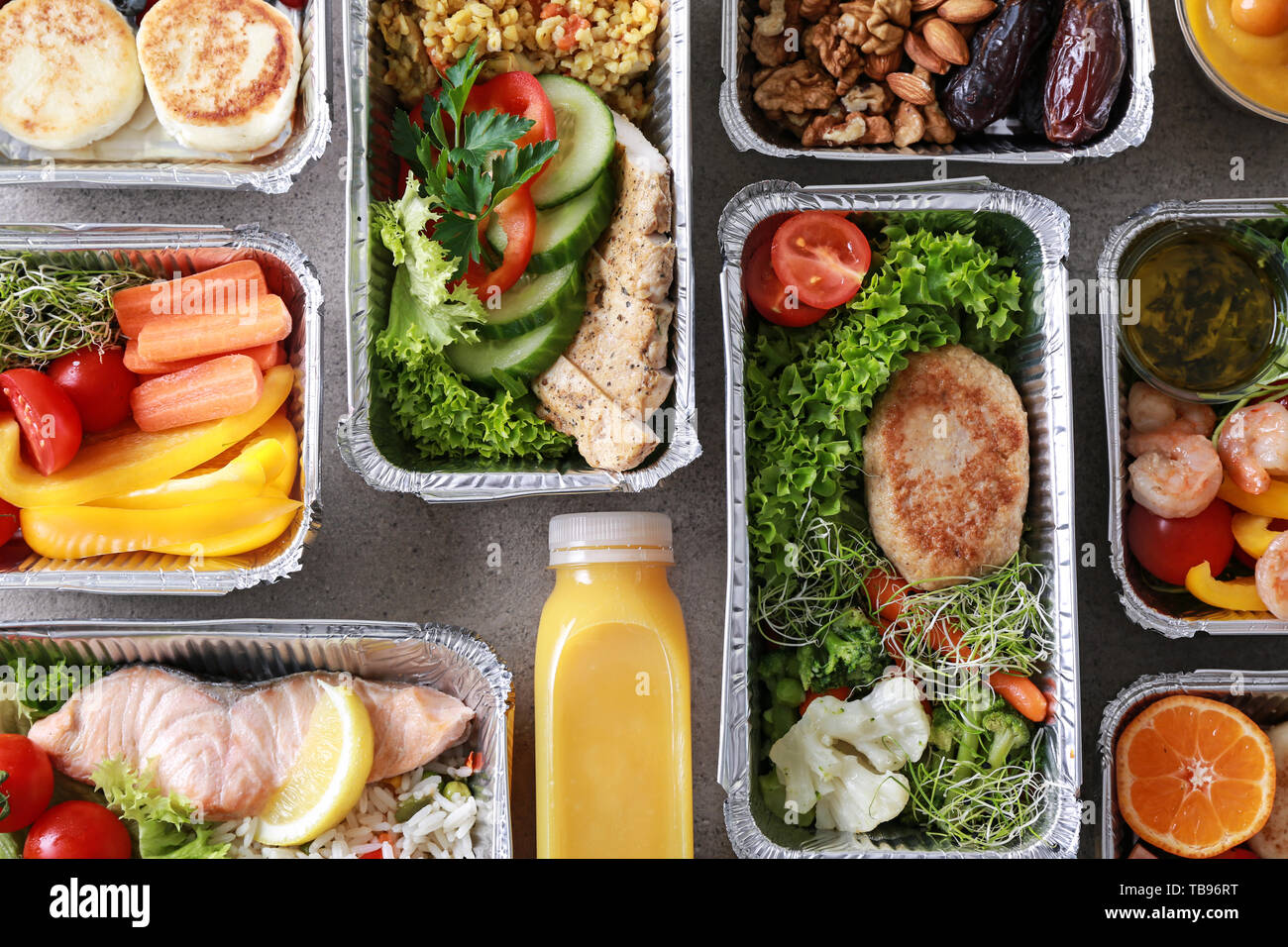 Containers with delicious food on grey background Stock Photo - Alamy